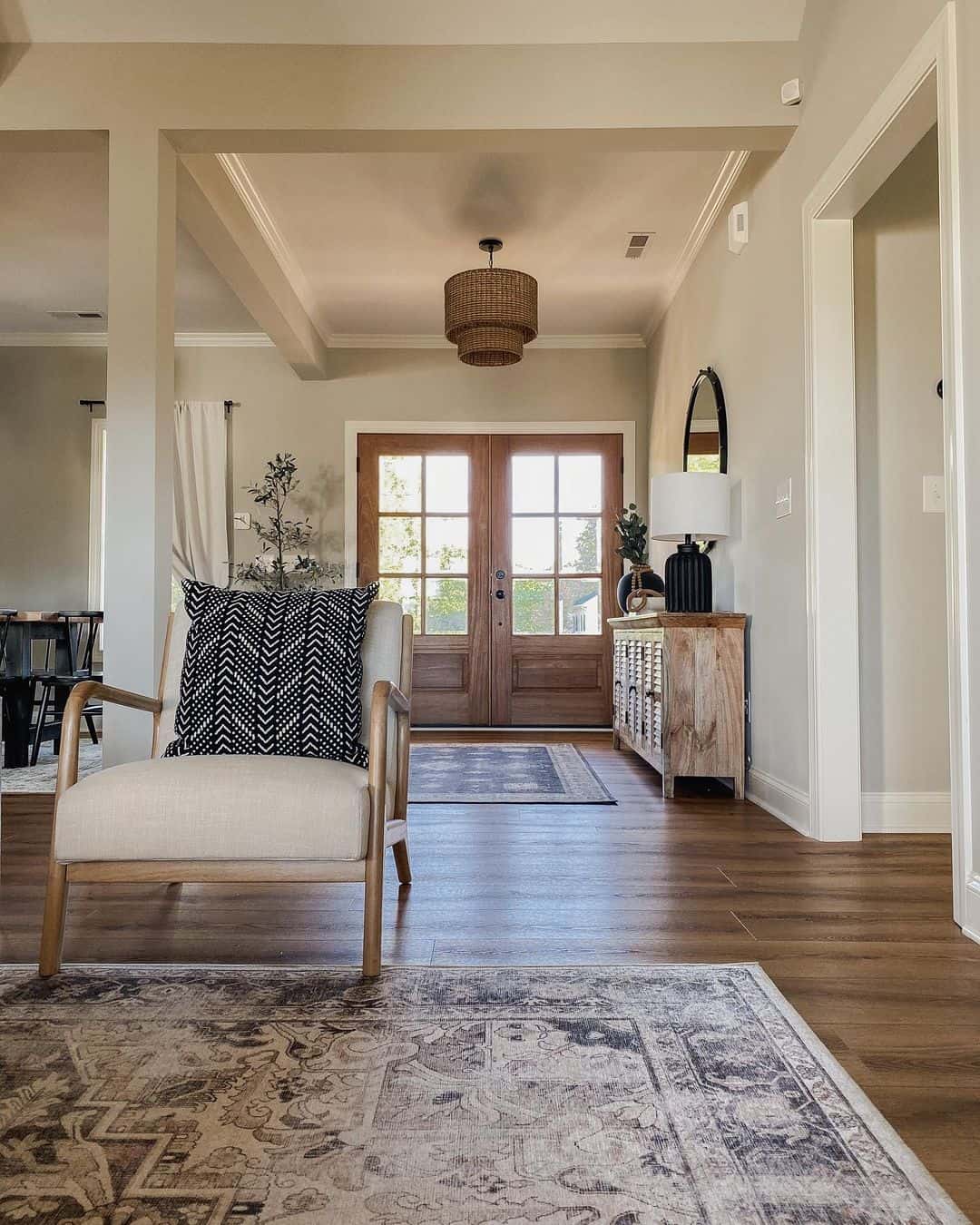 Rattan Hanging Light Over a Brown Entryway Rug - Soul & Lane