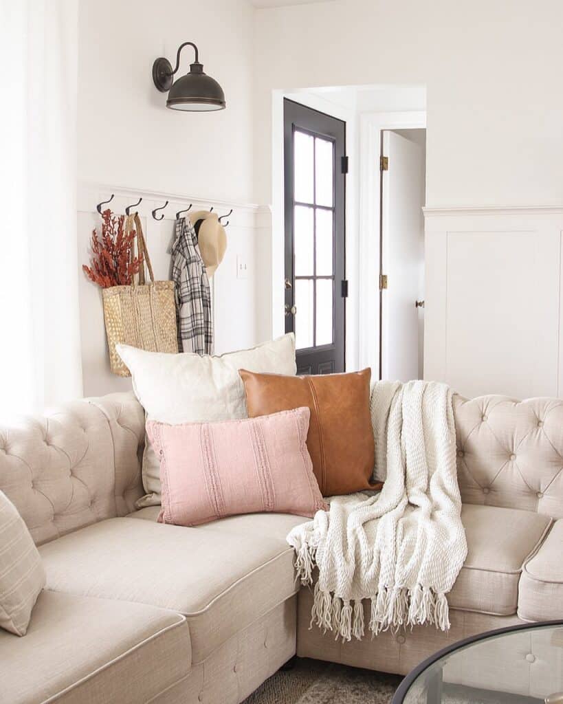 Beige Tufted Sofa with White, Pink, and Brown Leather Throw Pillows ...