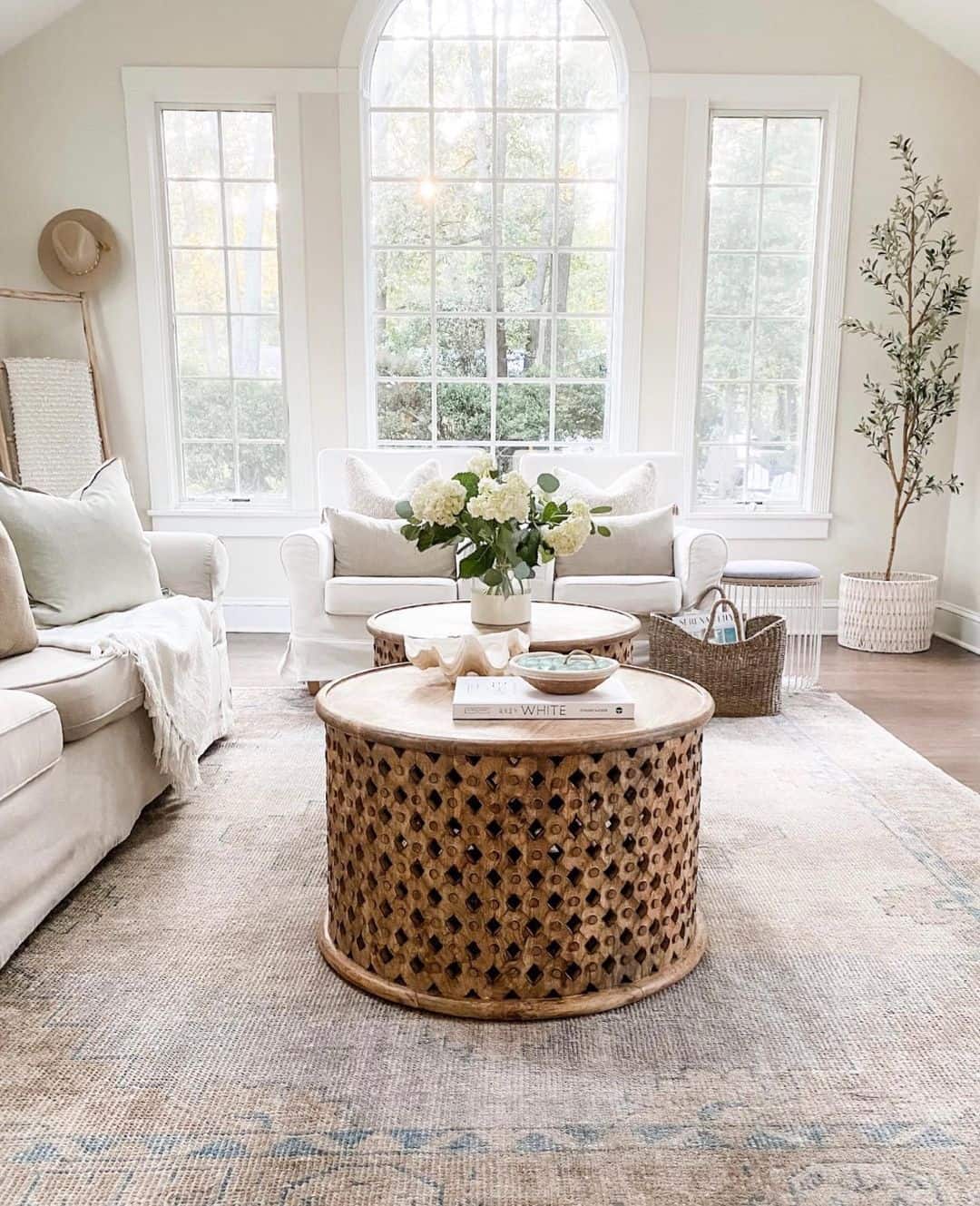 Well-Lit Living Room with Two Carved Wood Coffee Tables - Soul & Lane
